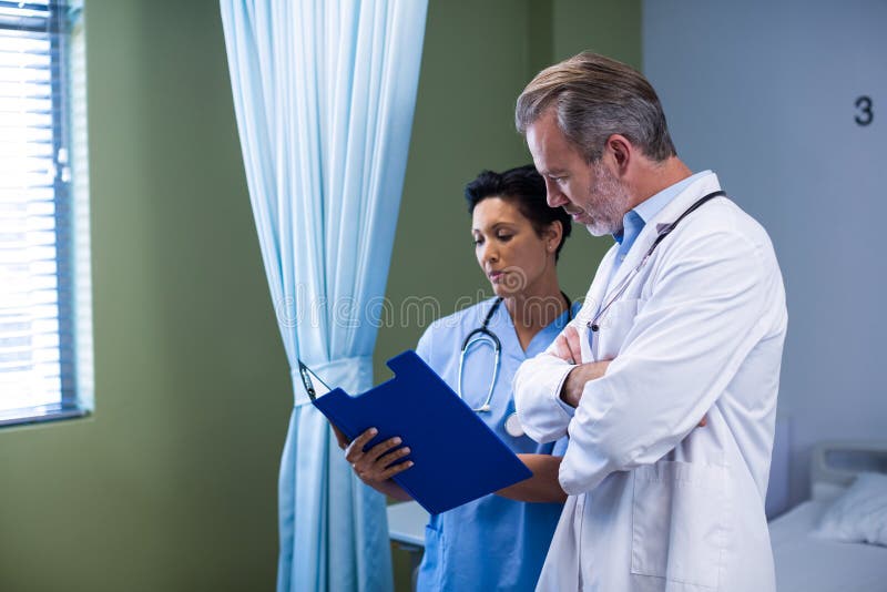 Doctor and Nurse Having Discussion on File in Ward Stock Image - Image ...