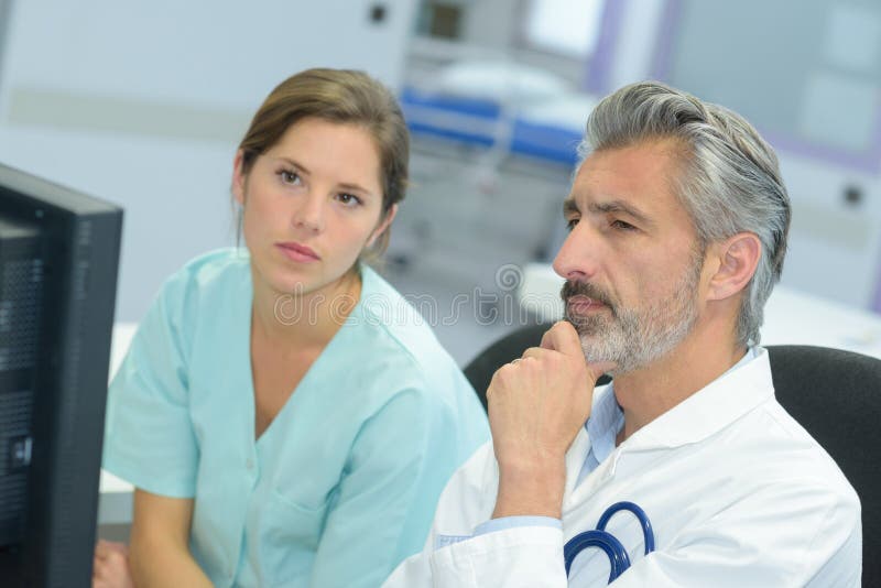 Doctor and Nurse Looking at Computer Screen Stock Photo - Image of room ...