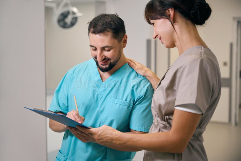 Doctor and Nurse Standing Signing Documents Stock Image - Image of ...