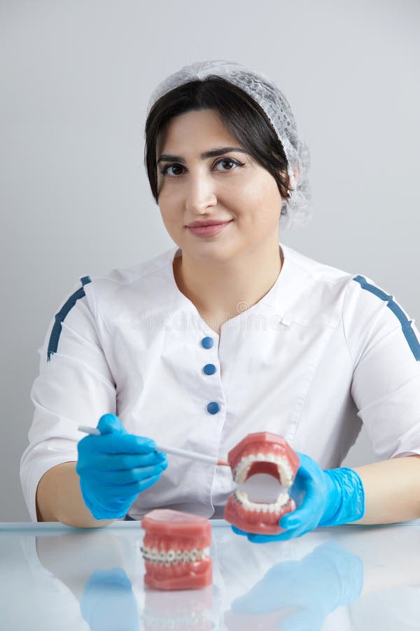 Orthodontist Showing Model of Human Jaw with Wire Braces and Aligners ...