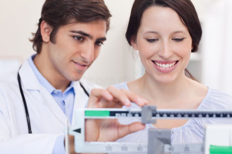 Doctor and Patient Adjusting the Scale Together Stock Image - Image of ...