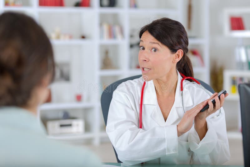 Doctor with Patient and Talking on Phone Stock Image - Image of ...