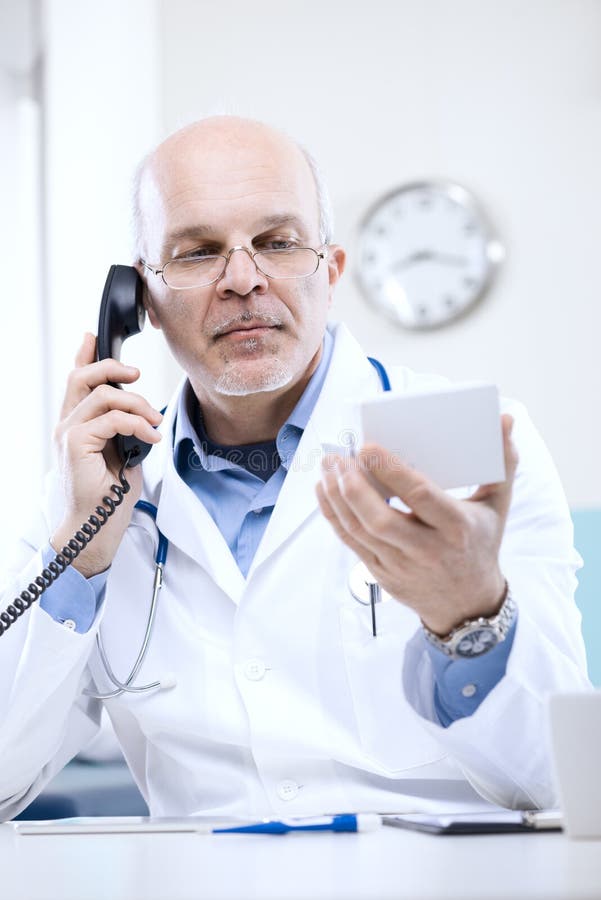 Doctor at phone stock photo. Image of healthcare, scrubs - 44562512