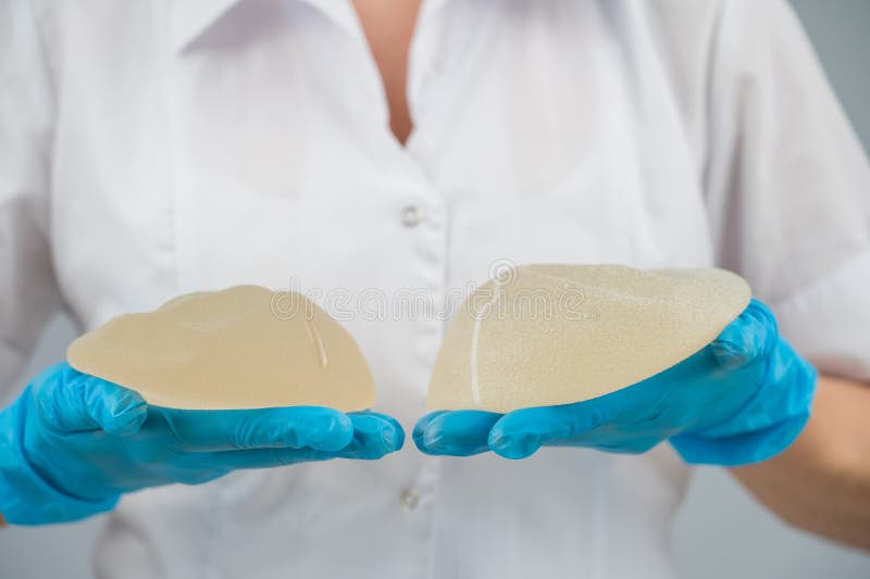 Doctor Plastic Surgeon Demonstrates Different Breast Implants. Stock ...