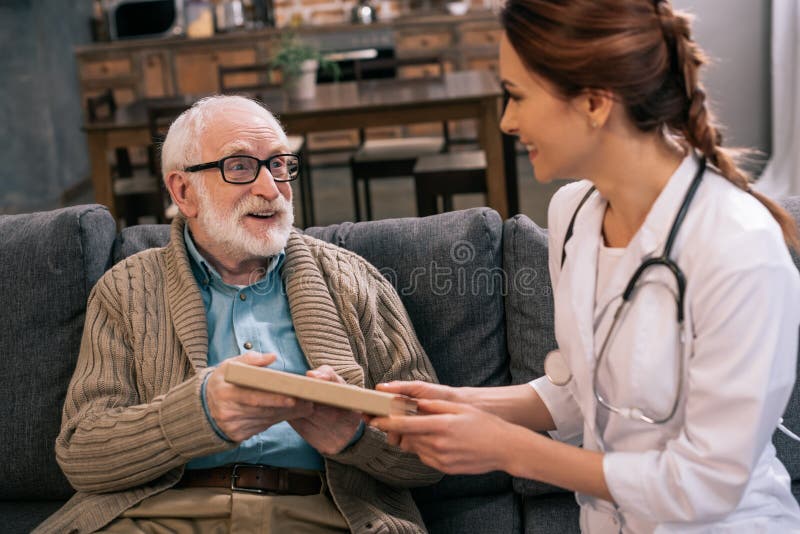 Doctor presenting book to stock image. Image of book - 129306157