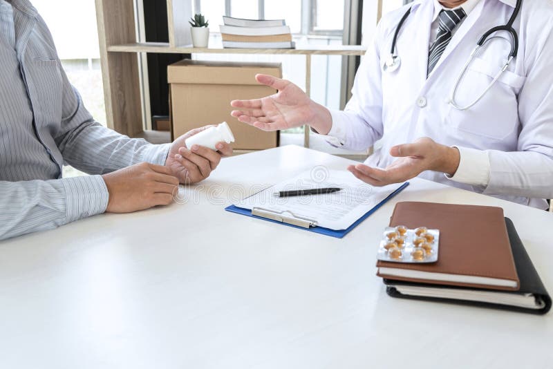 Doctor Presenting with Patient and Checking Results on Report and ...