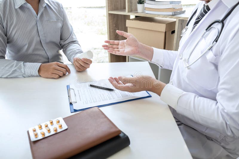 Doctor Presenting with Patient and Checking Results on Report and ...