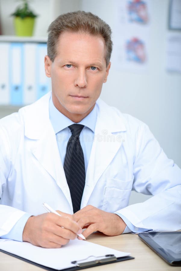 Doctor Profesional Que Se Sienta En La Tabla Foto de archivo - Imagen ...