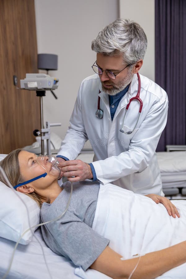 Doctor Putting an Oxygen Mask on a Female Patient Stock Image - Image ...
