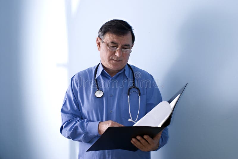 Doctor reading case notes stock photo. Image of physician - 14096466