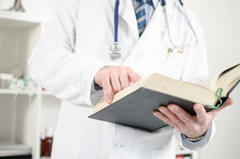 A Male Doctor Reading A Book In His Office Stock Image - Image of desk ...