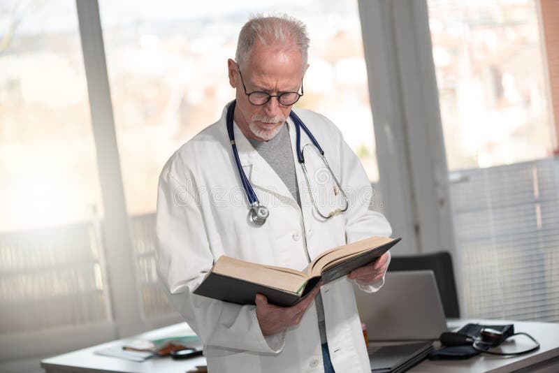 Doctor reading a textbook stock photo. Image of knowledge - 203441530