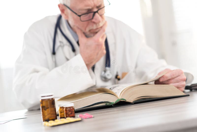 Doctor reading a textbook stock photo. Image of physician - 152737108