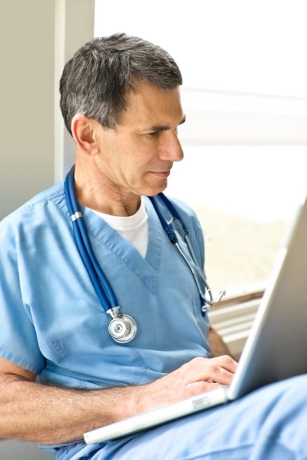 Doctor Reviewing His Notes on His Laptop Stock Photo - Image of nurse ...