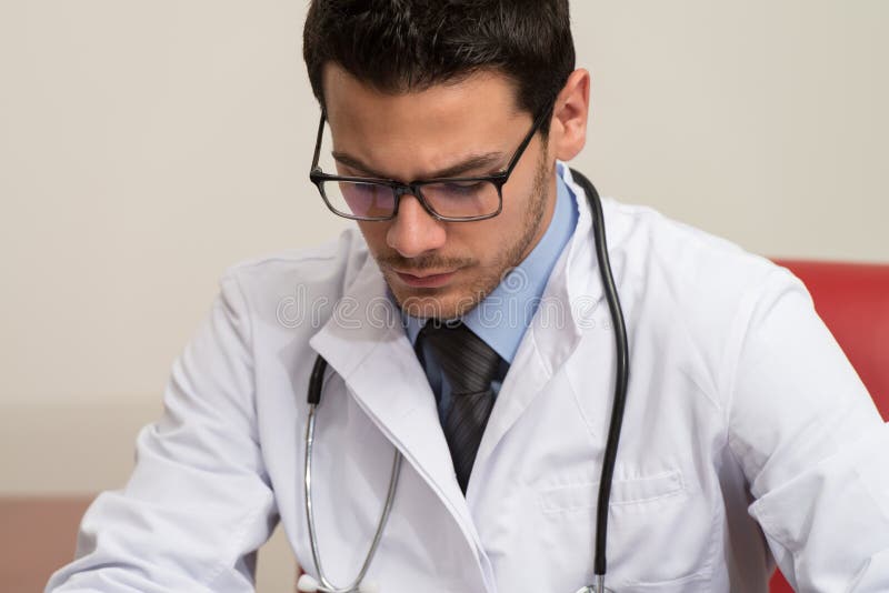 Doctor Sitting at Office Desk Signing a Contract Stock Image - Image of ...