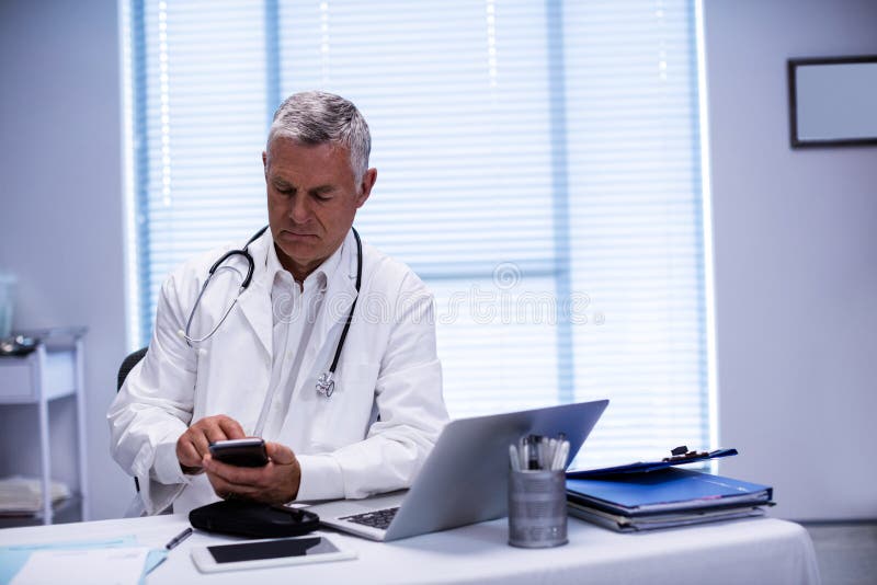 Doctor Sitting at Tablet and Using Mobile Phone Stock Photo - Image of ...