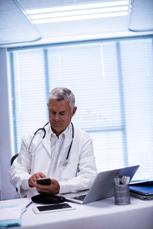 Doctor Sitting at Tablet and Using Mobile Phone Stock Image - Image of ...