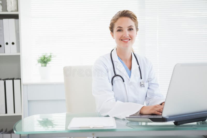 Doctor Smiling As she Types Stock Photo - Image of medical, female ...