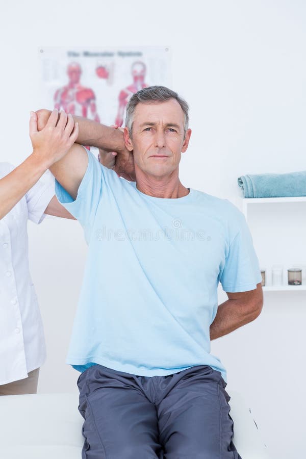 Doctor Stretching a Man Arm Stock Image - Image of care, body: 54759403