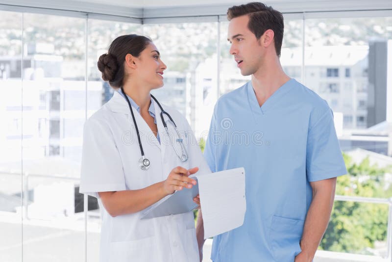 Doctor and Surgeon Chatting Together Stock Photo - Image of brunette ...