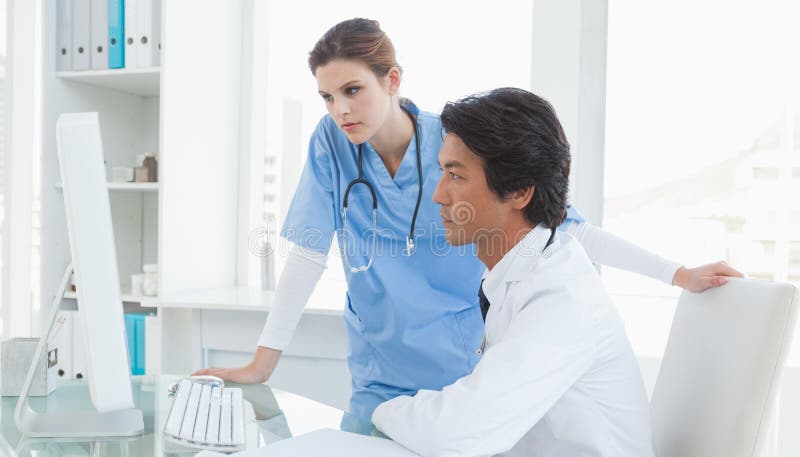 Doctor and Surgeon Looking at a Computer Stock Photo - Image of away ...