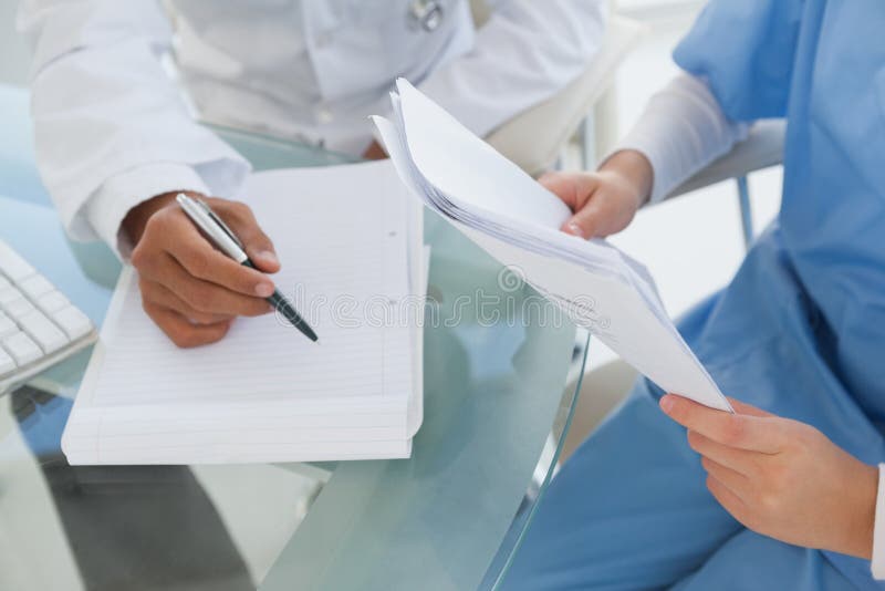 Doctor and Surgeon Reviewing Notes Stock Photo - Image of person ...
