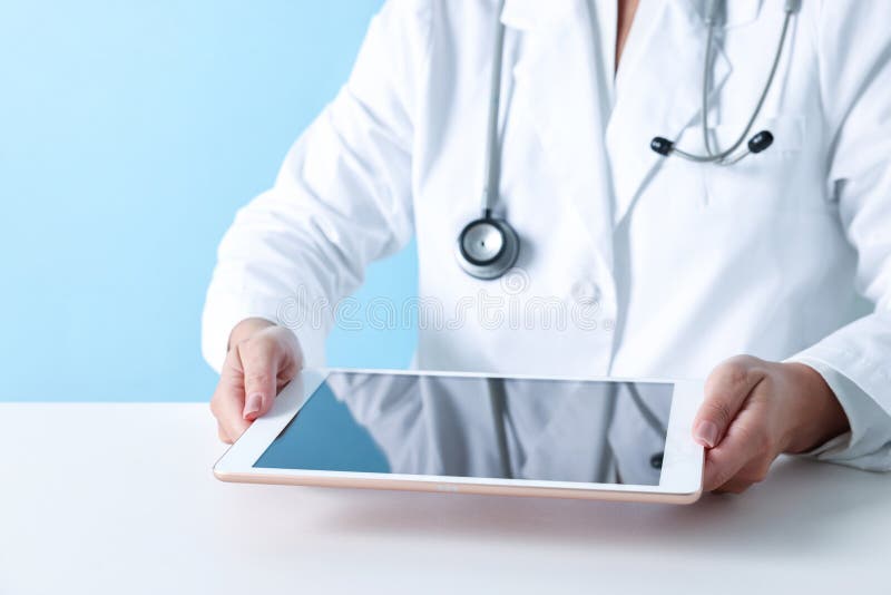 Doctor with Tablet at Table Against Light Blue Background, Closeup View ...