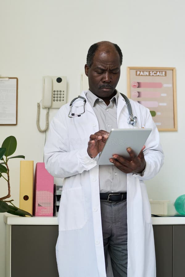 Doctor Taking Notes on Tablet in Medical Office Stock Photo - Image of ...