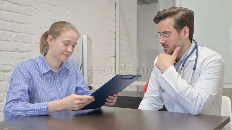 Doctor Taking Signature on Documents from Patient in Hospital Stock ...