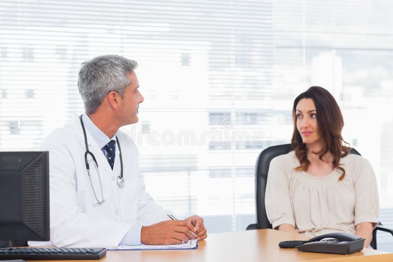 Doctor Talking with His Patient and Writing on Notebook Stock Photo ...