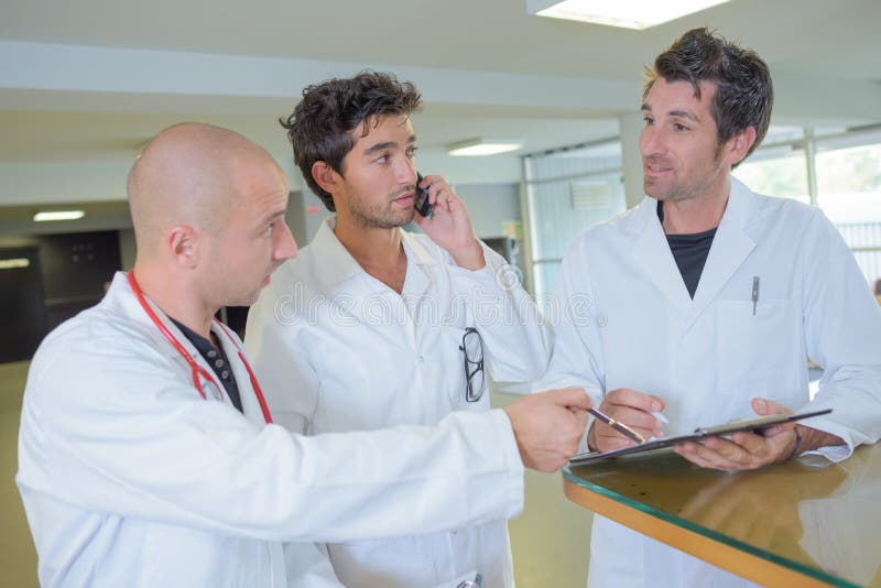 Doctor Talking on Mobile Phone with Other Doctors Stock Photo - Image ...