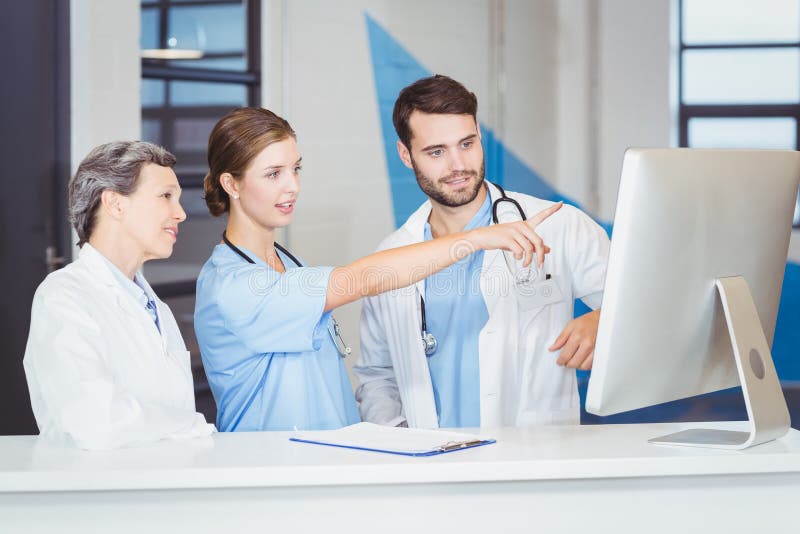 Doctor Team Discussing at Computer Desk Stock Photo - Image of indoors ...