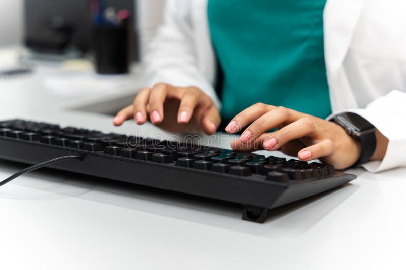 A Doctor Types on the Computer Keyboard while Visiting with a Seated ...