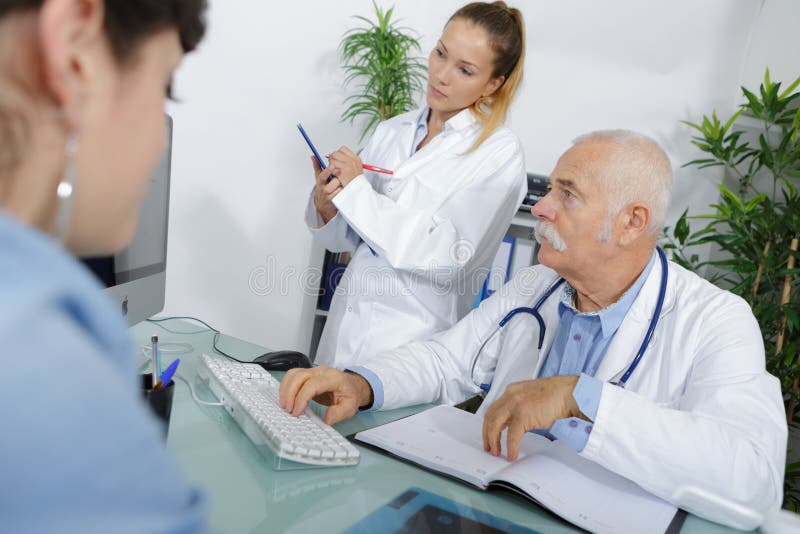 Doctor Using Computer while in Consultation with Female Patient Stock ...