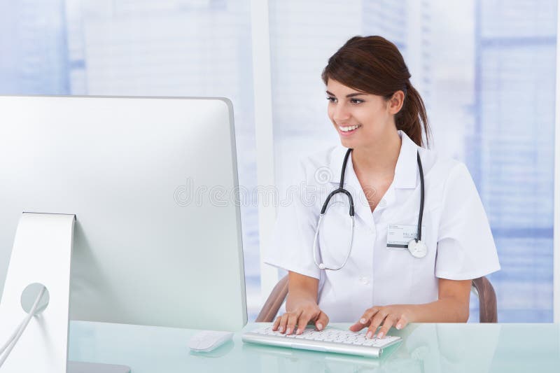Doctor Using Computer at Desk in Clinic Stock Photo - Image of adult ...