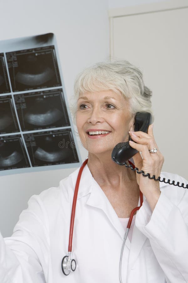 Doctor Using Landline Phone while Analysing X-Ray Report Stock Photo ...