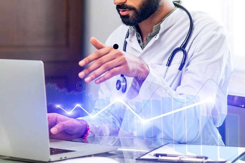 A Doctor is Using a Laptop Computer while Talking on the Phone Stock ...