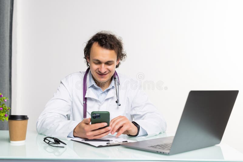 Doctor Using Mobile Smart Phone, Working on Laptop Computer during the ...