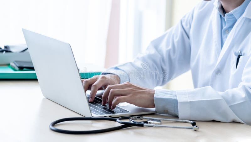 Doctor is Using a Notebook Computer, in Search of Information and Write ...