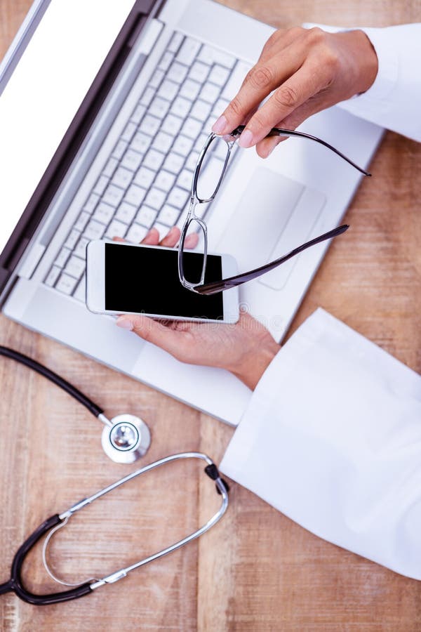 Doctor Using Smartphone on Wooden Desk Stock Image - Image of examining ...