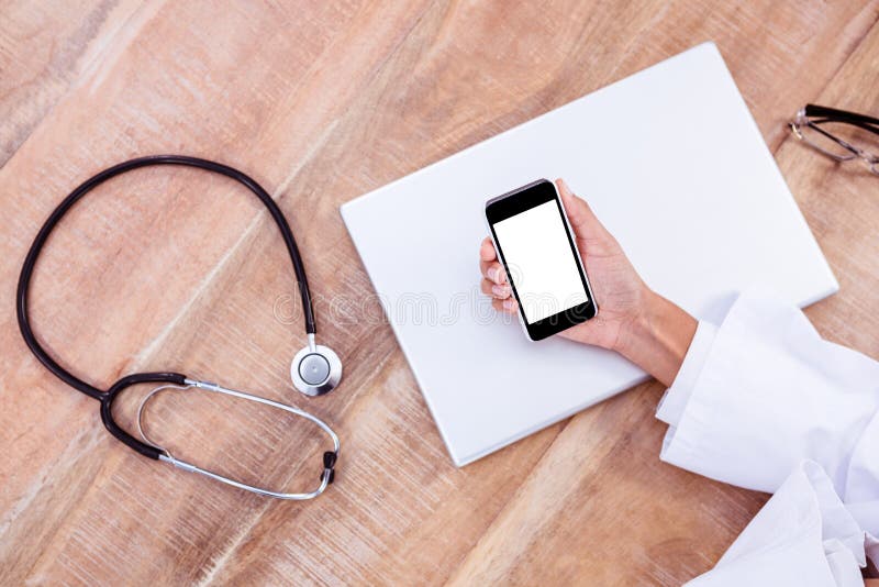 Doctor Using Smartphone on Wooden Desk Stock Image - Image of ...