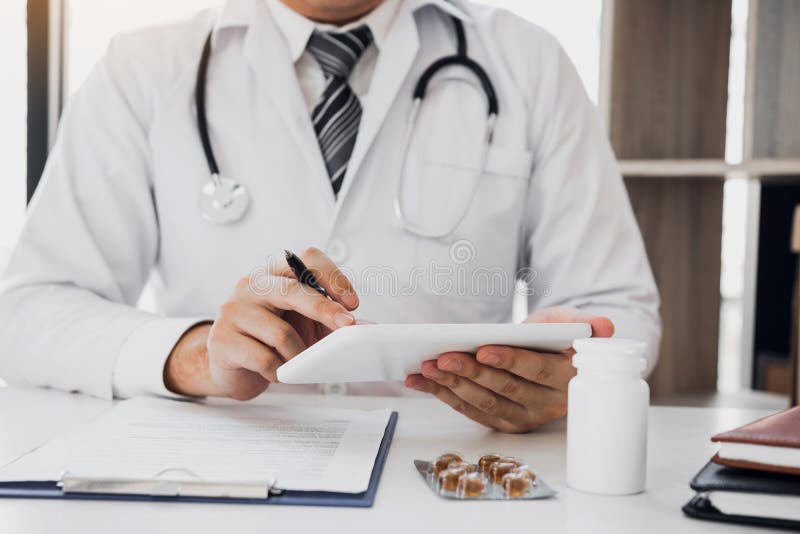 The Doctor is Using a Tablet To View the Patient`s Treatment Data and ...