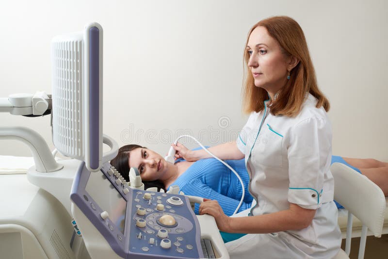 Doctor Using Ultrasound Scanning Machine Examining Female Neck Stock