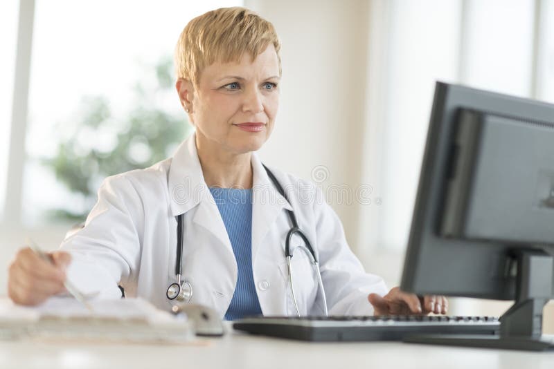 Doctor and Nurse Reviewing on Laptop Computer in O Stock Photo - Image ...