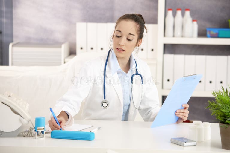 Doctor working at desk stock image. Image of concentrating - 21446343