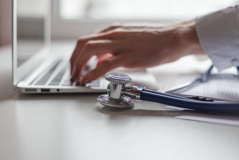 Doctor Working with Laptop Computer in Medical Workspace Office. Focus ...