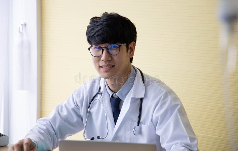 Doctor Working with Laptop Computer and Writing on Paperwork Stock ...