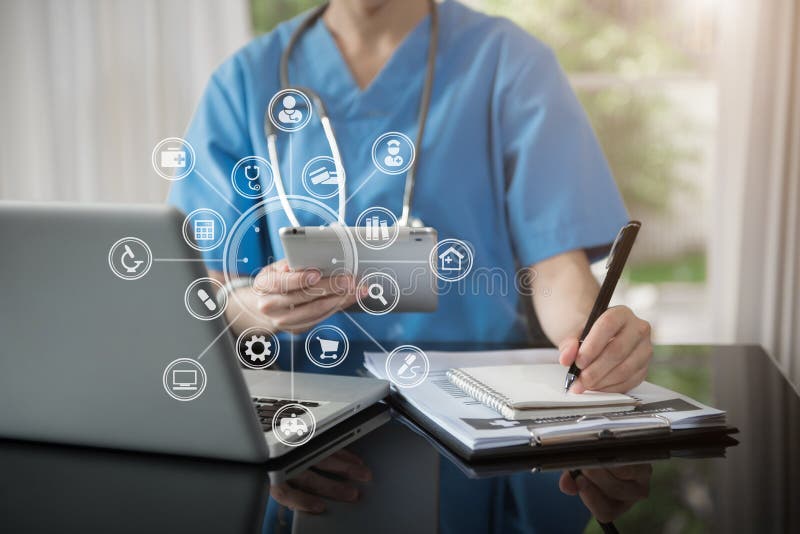 Doctor Working with Laptop Computer and Writing on Paperwork. in the ...