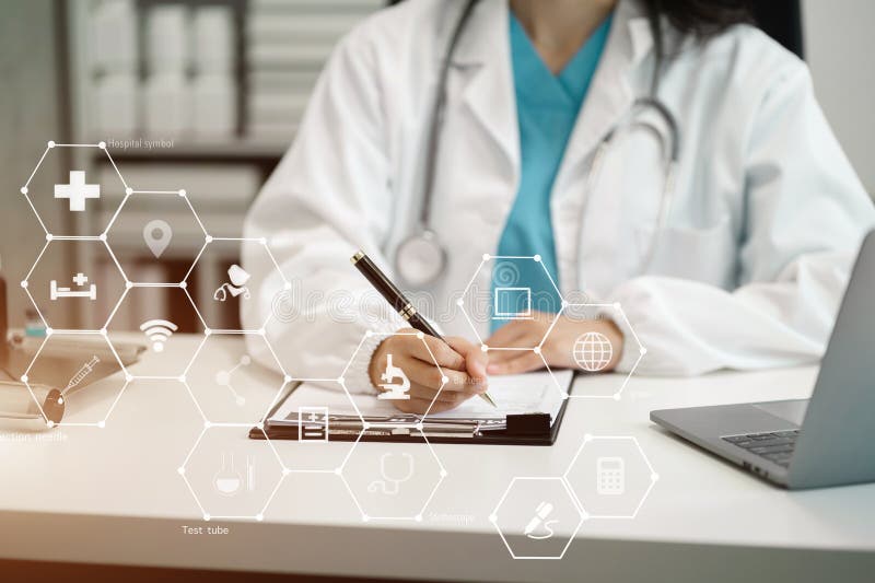 Doctor Working with Laptop Computer and Writing on Paperwork. in the ...