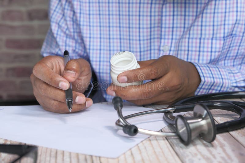 Doctor Writing Documents at Desk in Clinics . Stock Photo - Image of ...